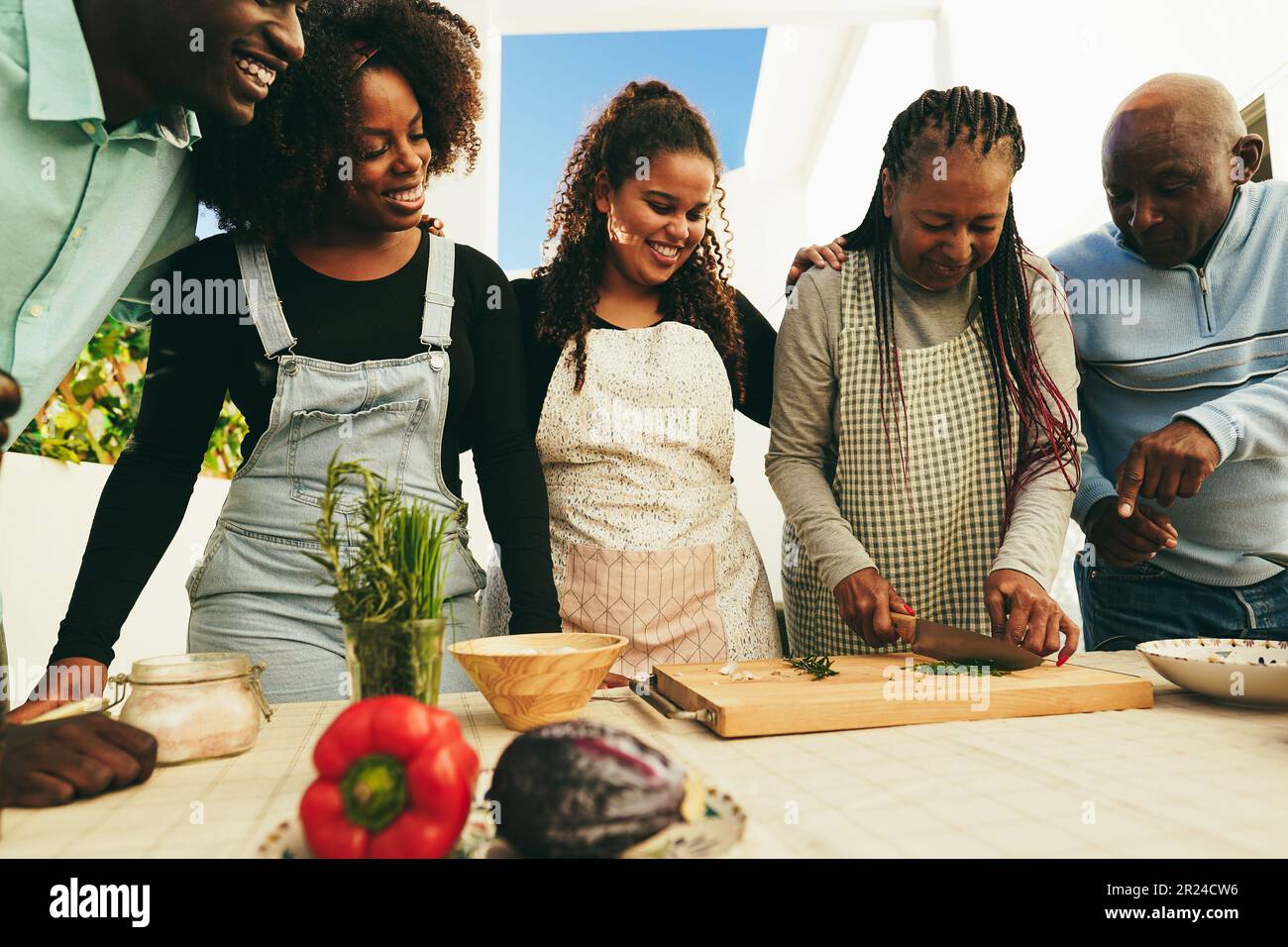 Happy african family cooking together outdoor at home terrace - Focus ...