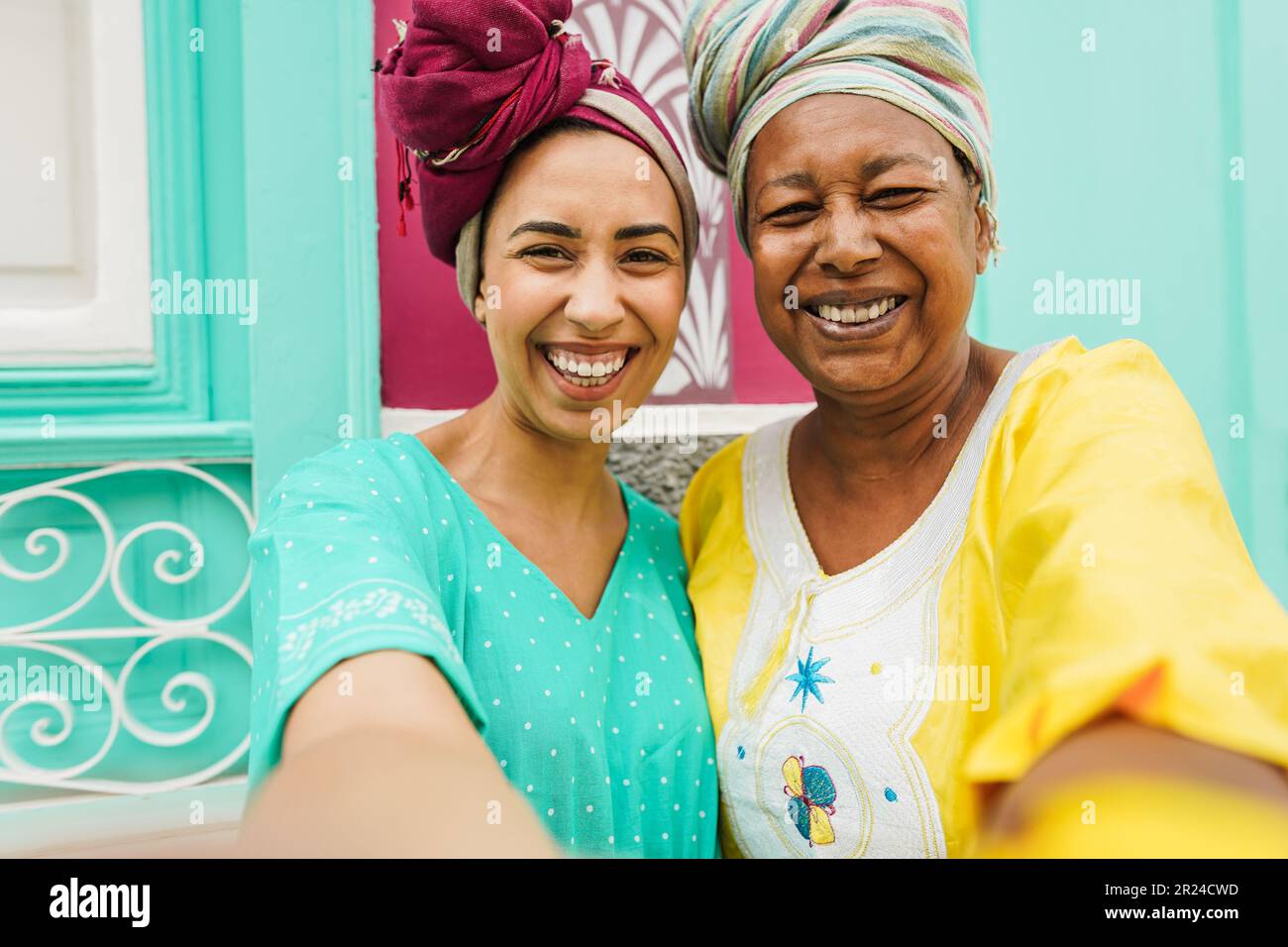 Happy african mother and daughter taking selfie in front of traditional ...