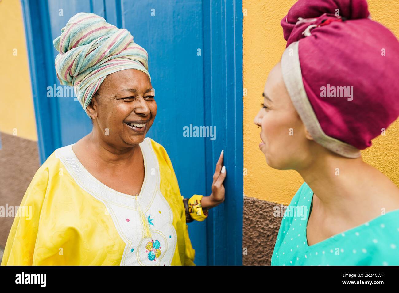 Happy african mother and her daughter wearing afro clothes while ...