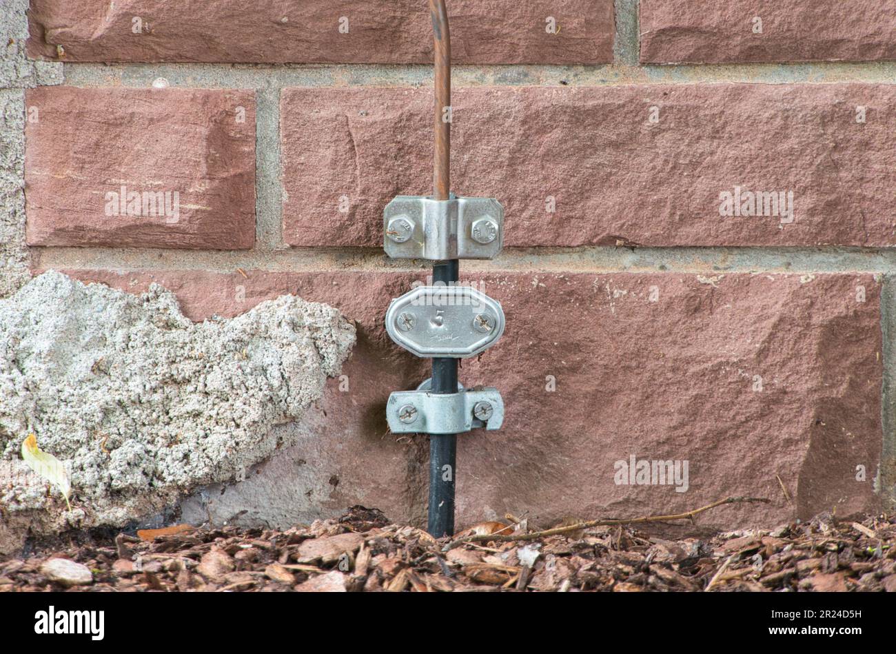 A metal lightning rod affixed to a natural stone wall Stock Photo - Alamy