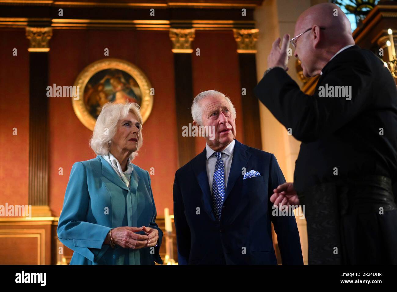 Britain's King Charles III, center, and Queen Camilla speak with the ...