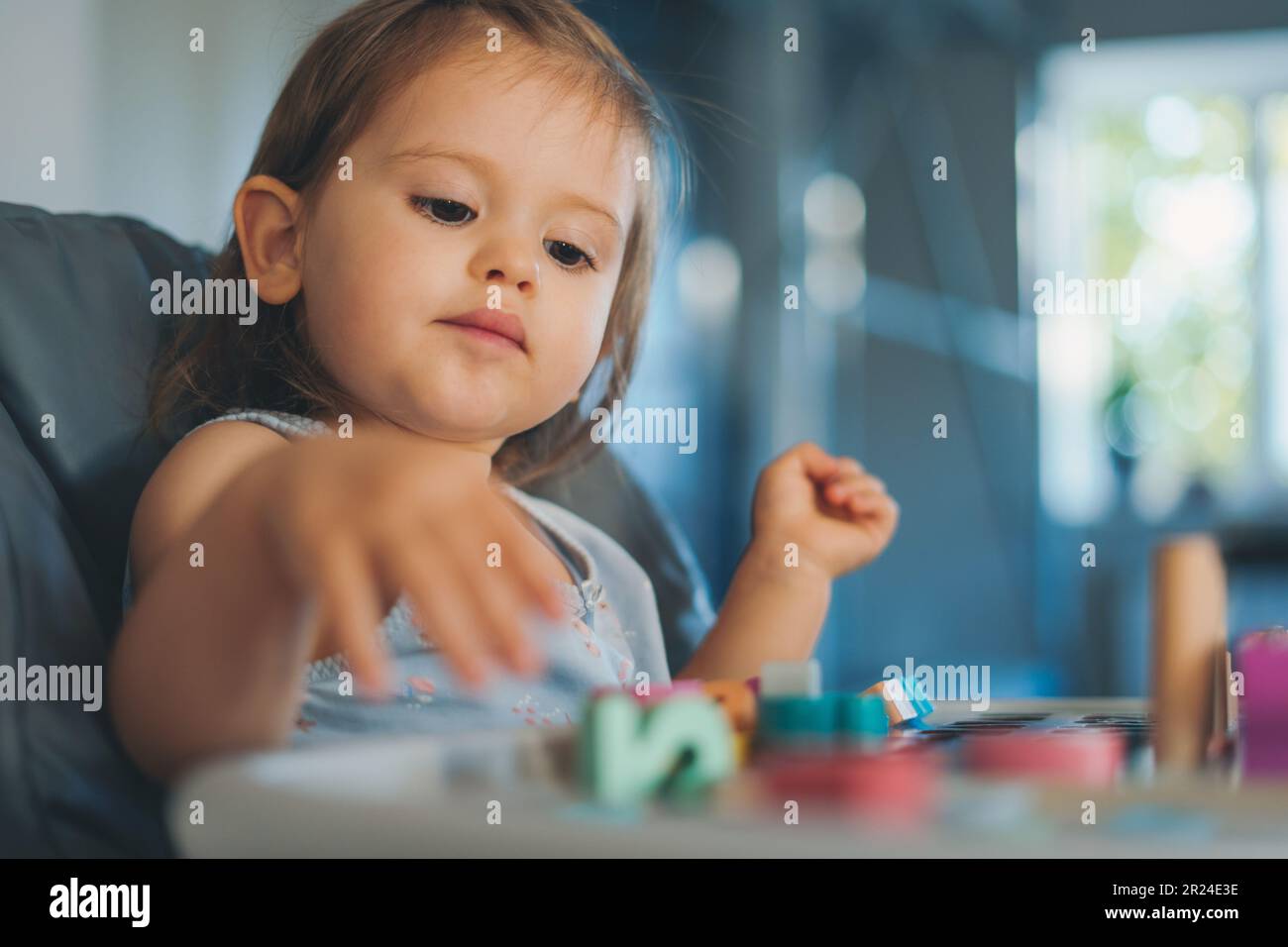 Baby child girl concentrated while playing with educational toys in ... Baby child girl concentrated while playing with educational toys in ...