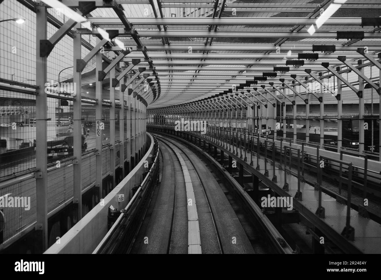 A grayscale shot of a subway station featuring a large number of tracks ...