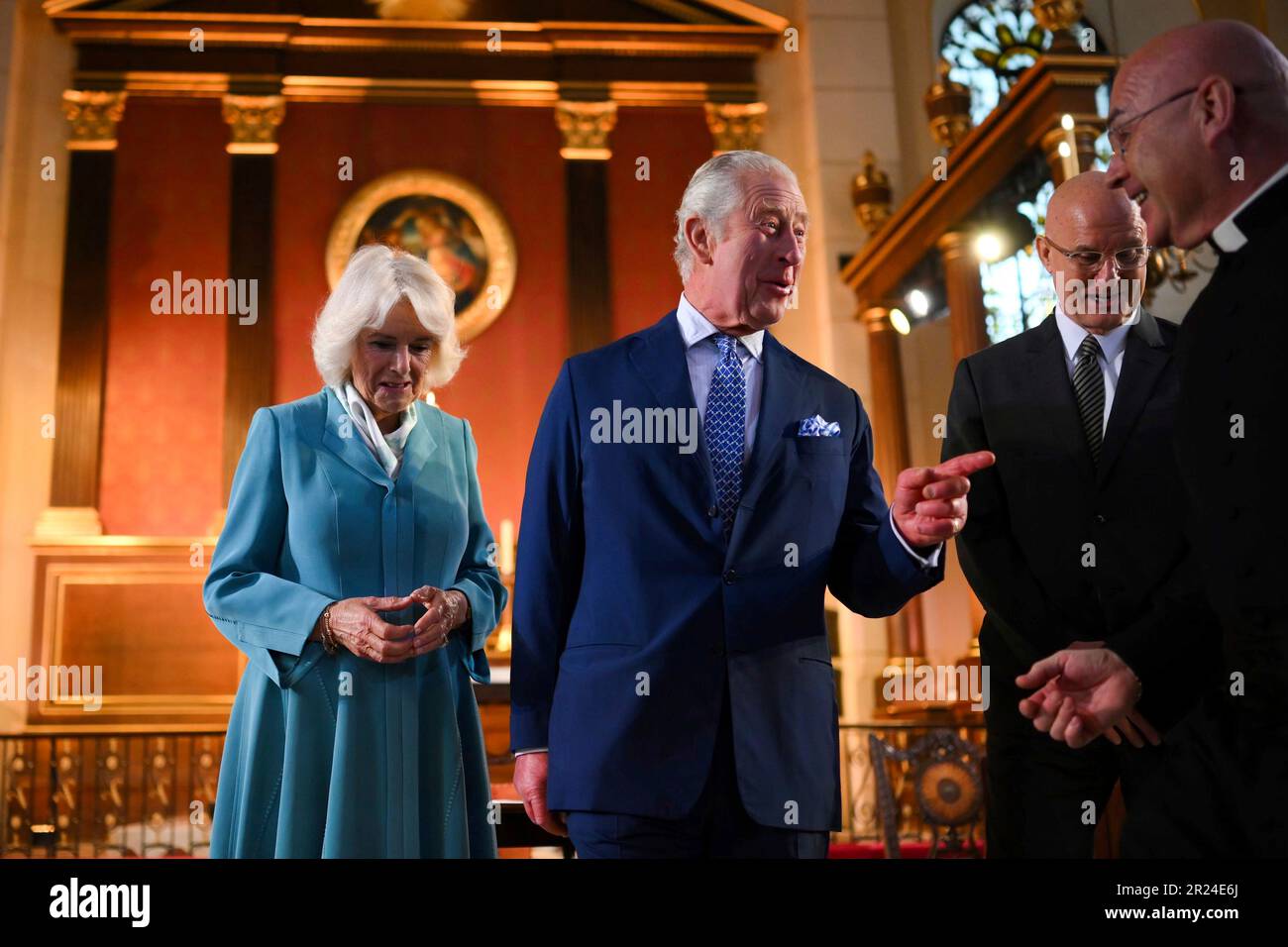 Britain's King Charles III, center, and Queen Camilla speak with the ...