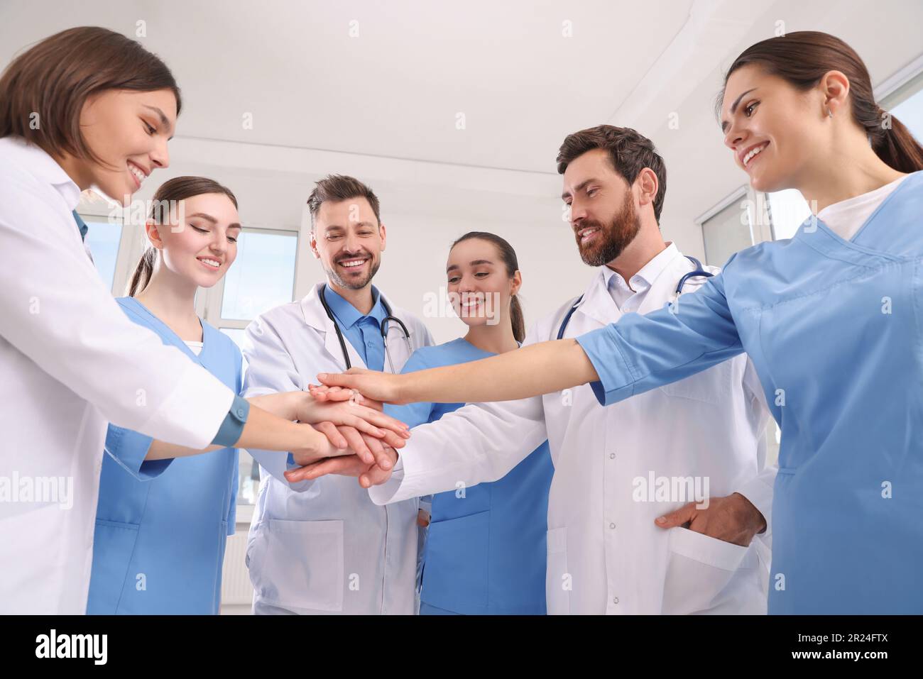 Team of medical doctors putting hands together indoors Stock Photo - Alamy