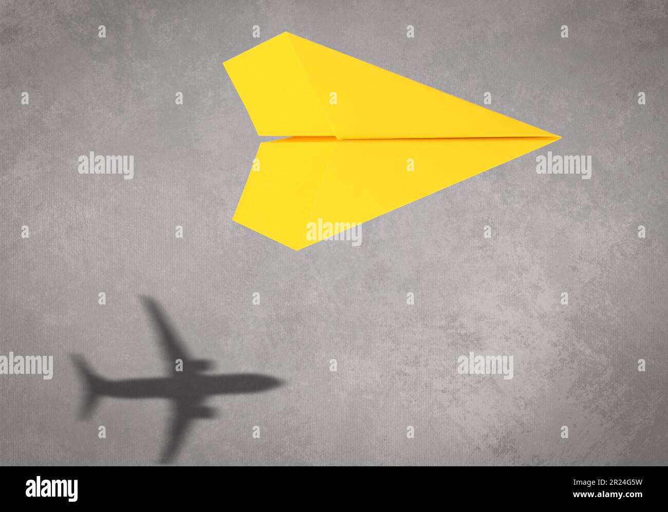 Flying paper plane and shadow of a real airplane on grey background ...