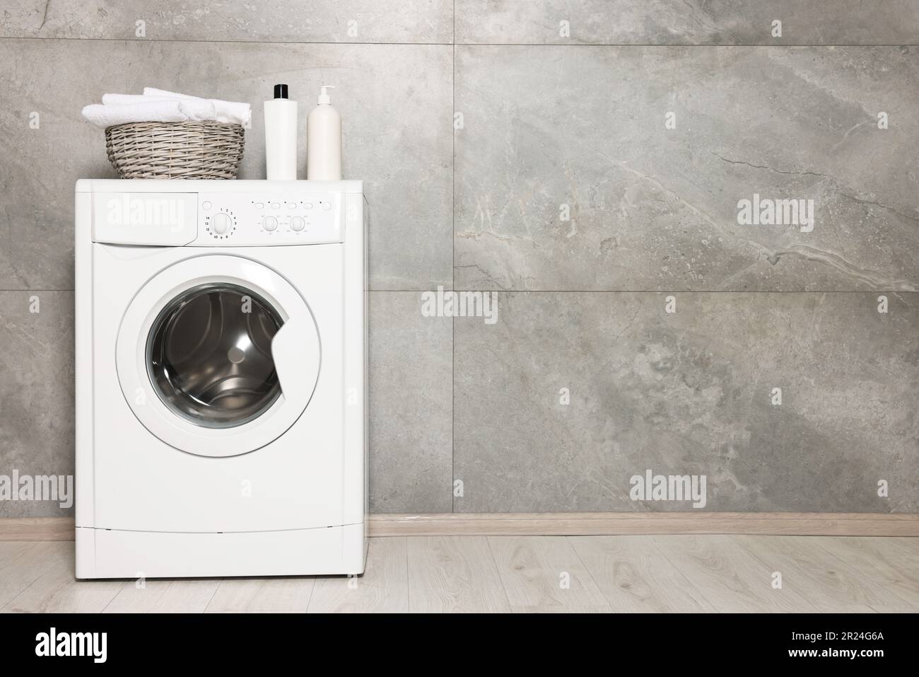 Stylish laundry room with modern washing machine, space for text ...