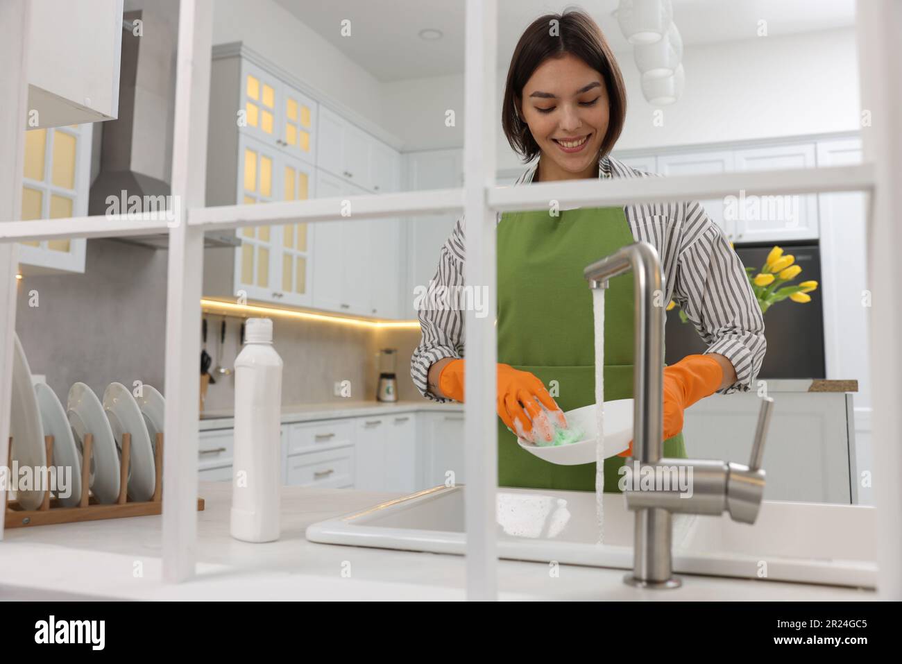 Happy young woman washing plate above sink in modern kitchen Stock ...