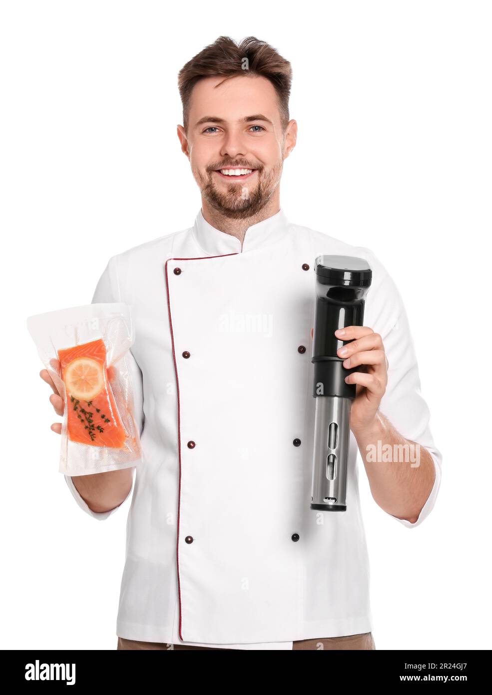 Chef holding sous vide cooker and salmon in vacuum pack on white ...