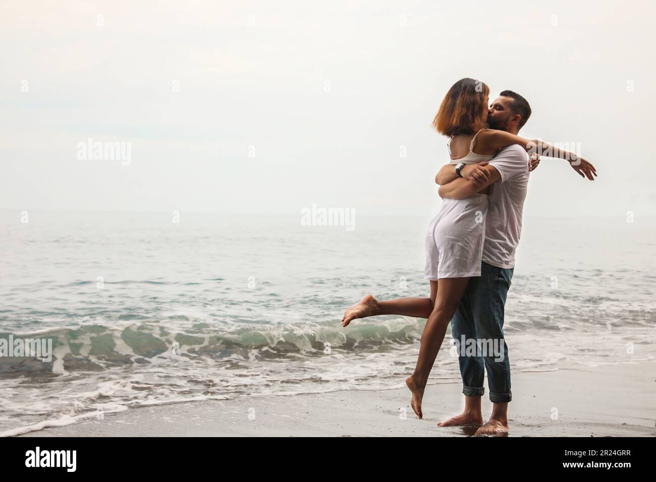Young couple kissing on beach near sea. Space for text Stock Photo - Alamy
