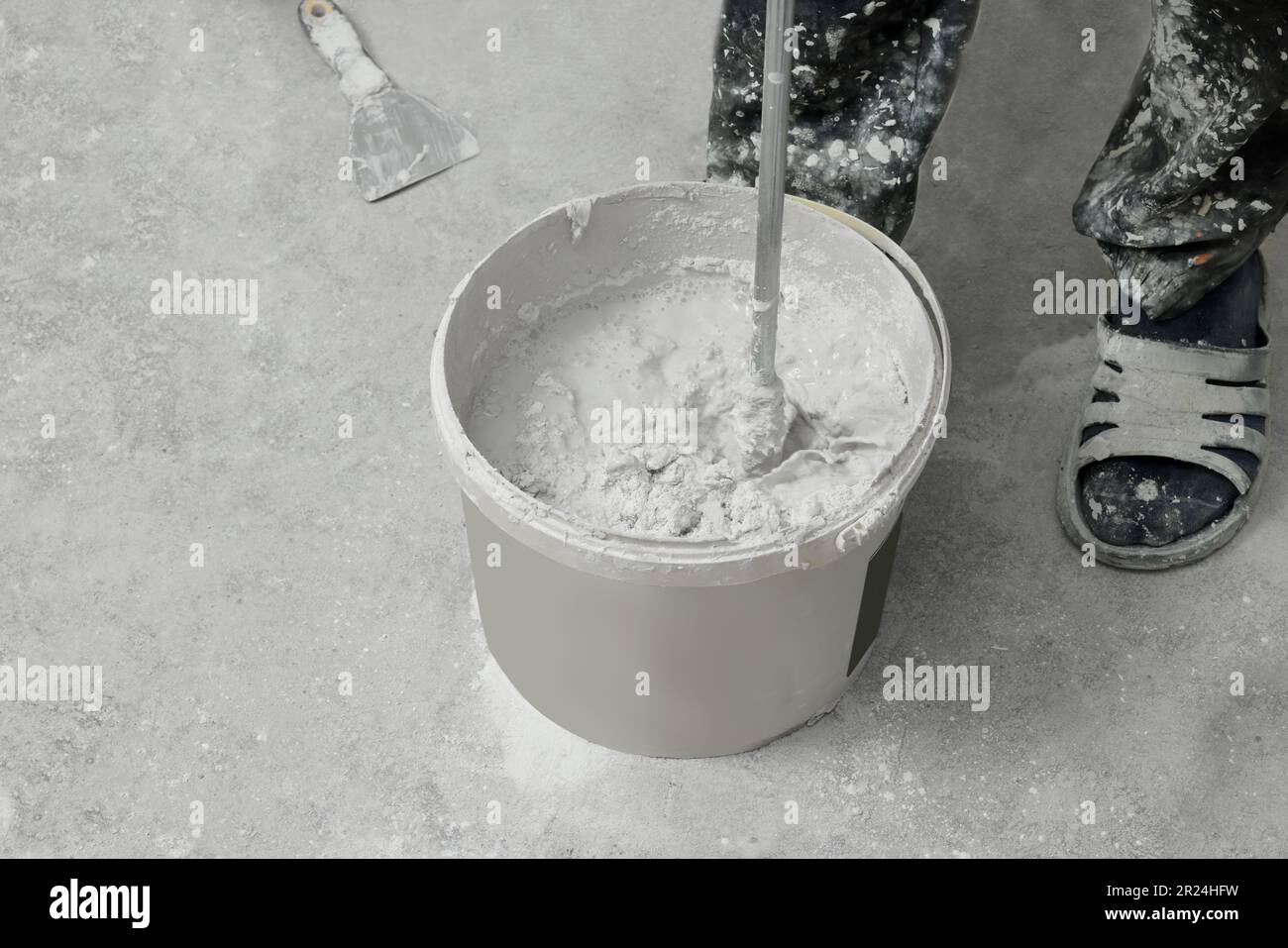 Professional worker mixing plaster in bucket indoors, closeup Stock ...