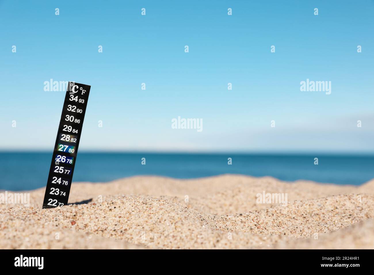 Weather thermometer in sand near sea, space for text Stock Photo - Alamy
