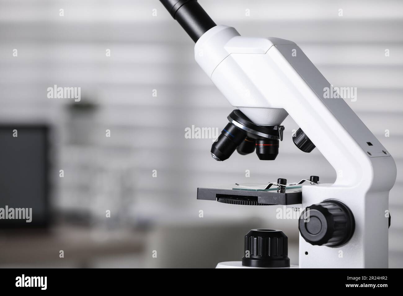 Modern medical microscope on blurred background, closeup with space for ...