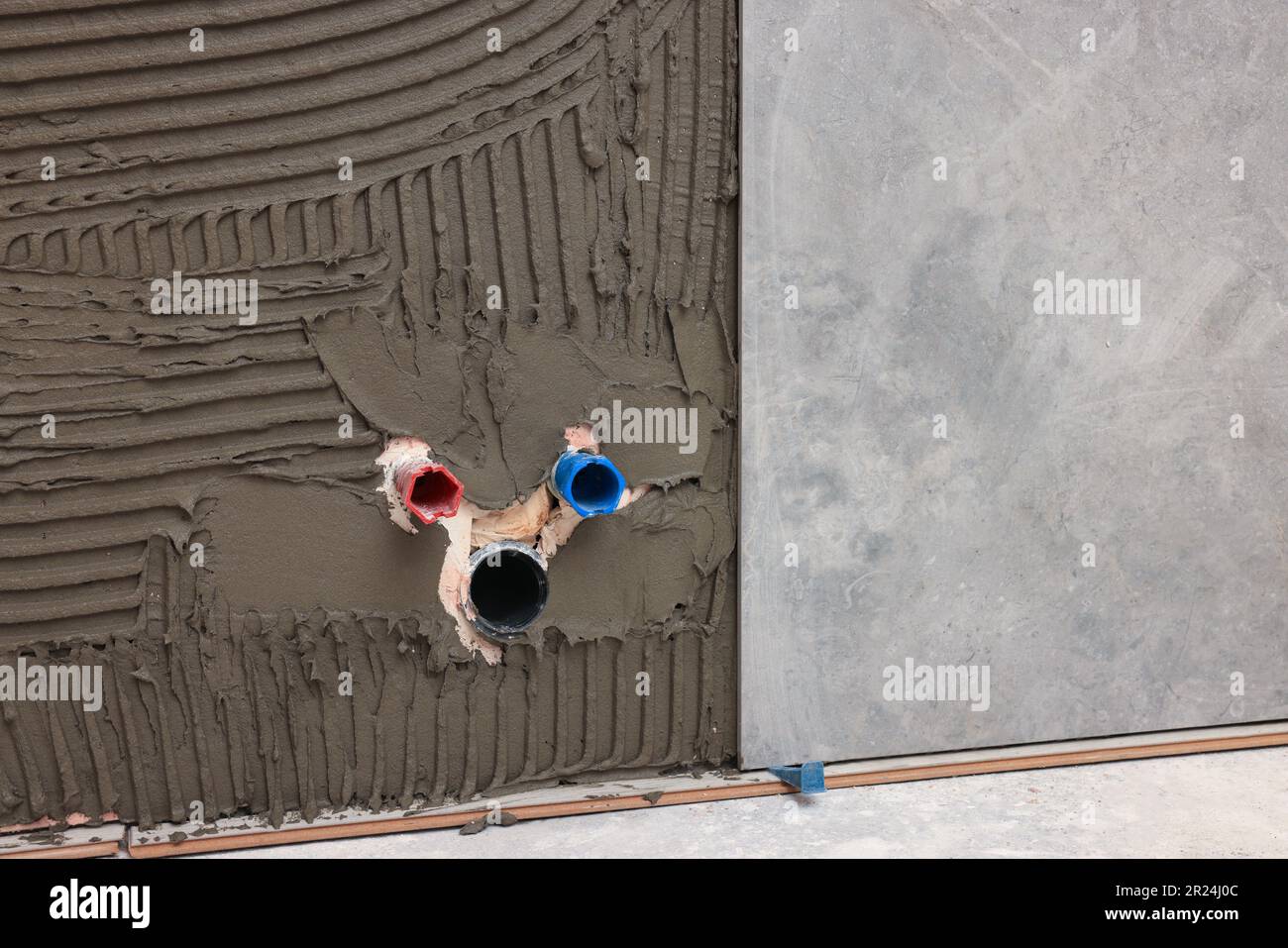 Adhesive mix and tile on wall indoors Stock Photo - Alamy