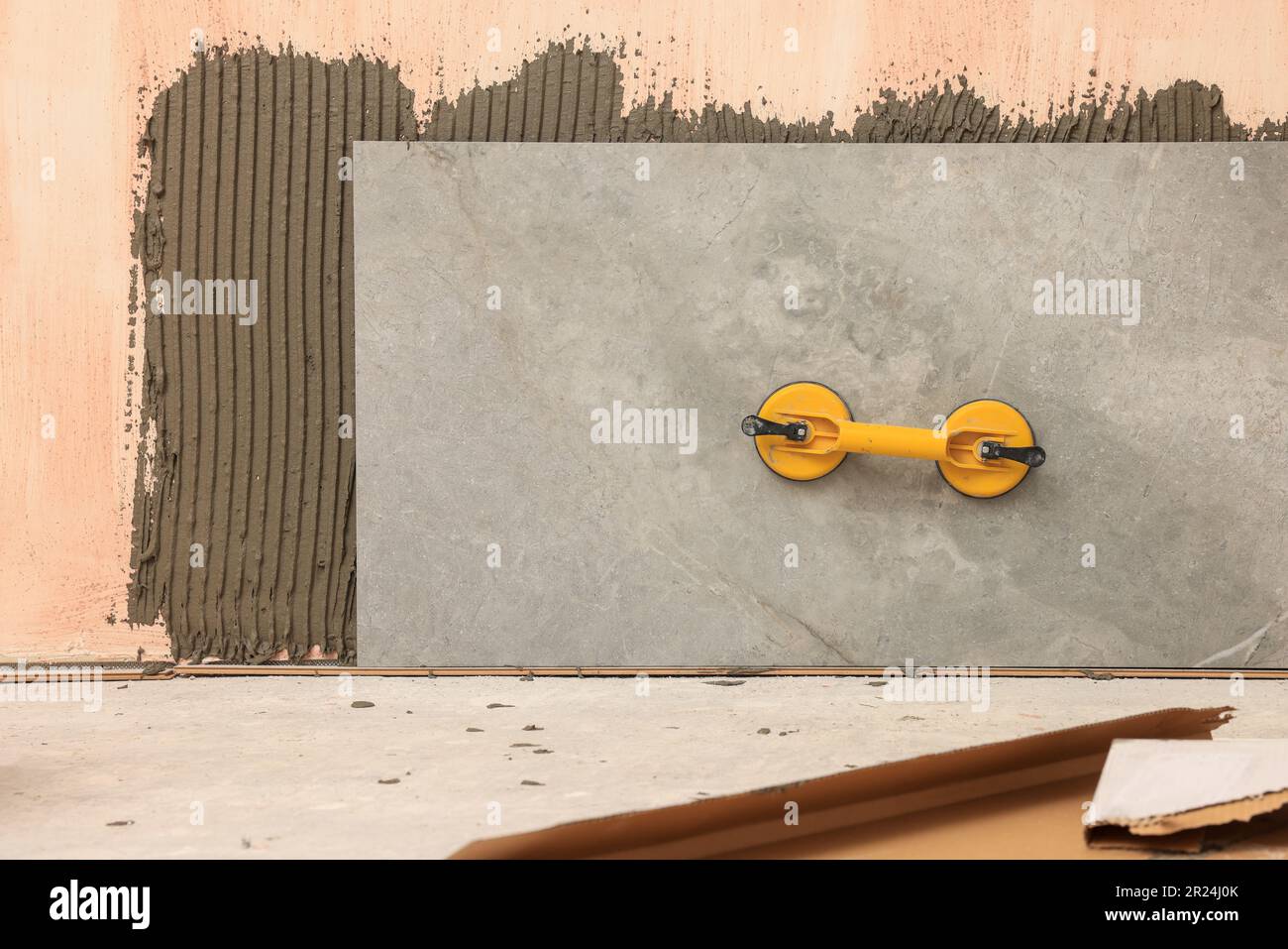 Yellow suction plate attached to tile on wall indoors Stock Photo - Alamy