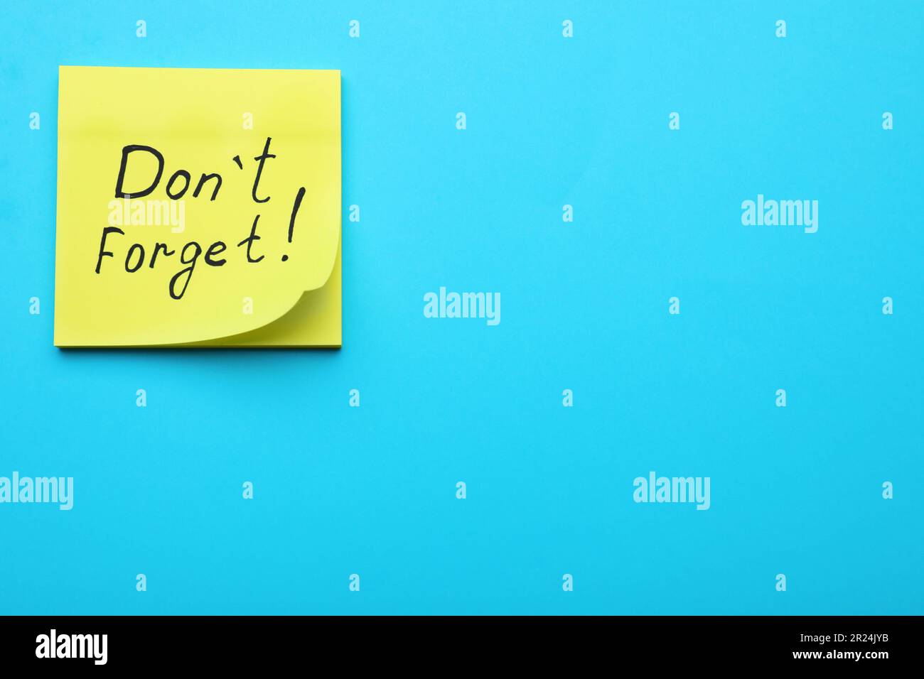 Paper note with phrase Don' t Forget on blue background, top view ...