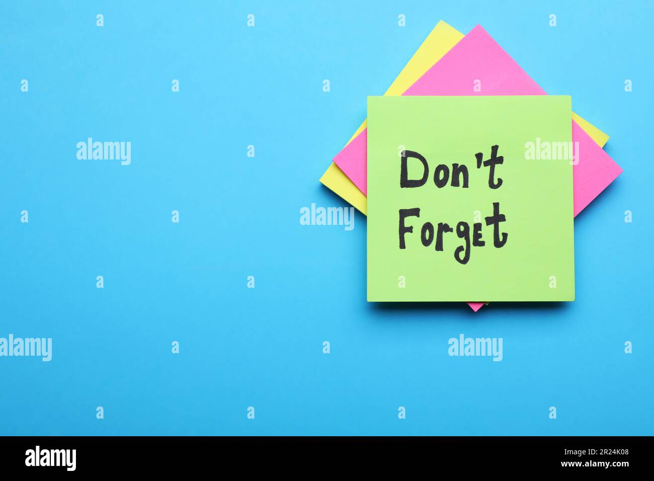 Paper note with phrase Don' t Forget on blue background, top view ...