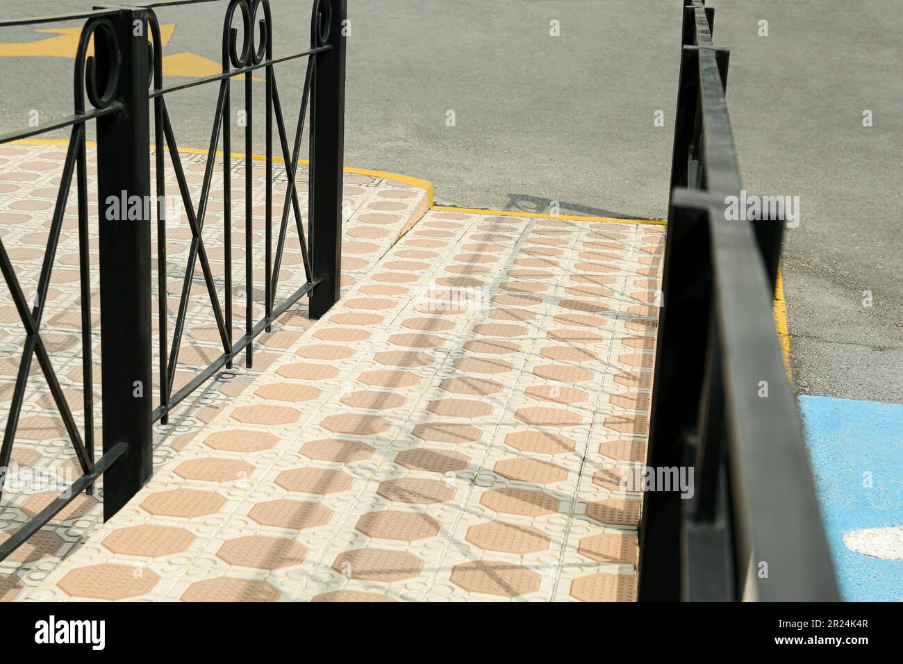Tiled ramp with black metal railings outdoors Stock Photo - Alamy