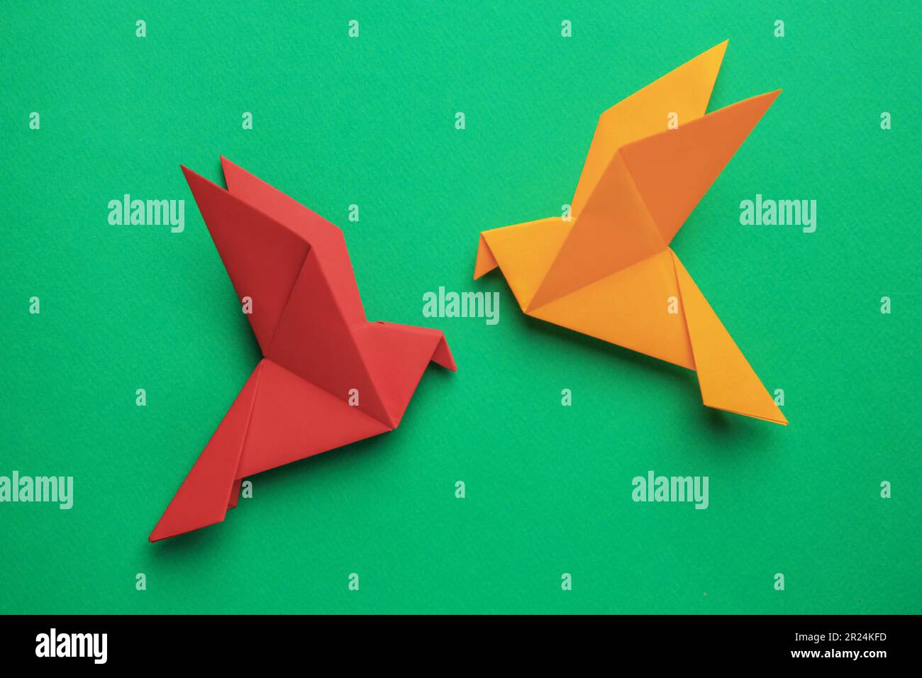 Beautiful colorful origami birds on green background, flat lay Stock ...