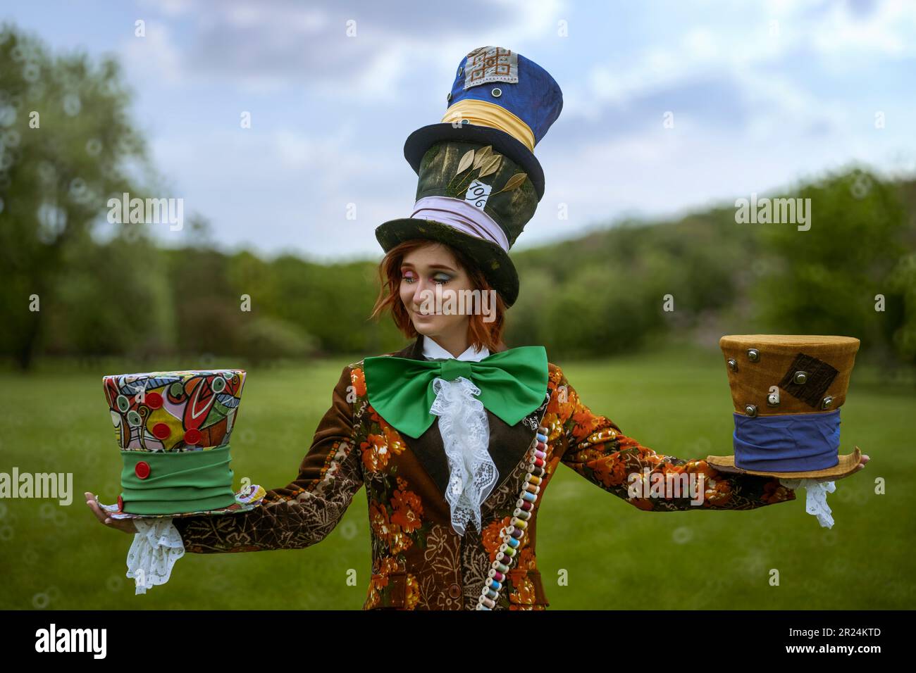Beautiful woman as mad hatter with hats in nature Stock Photo - Alamy