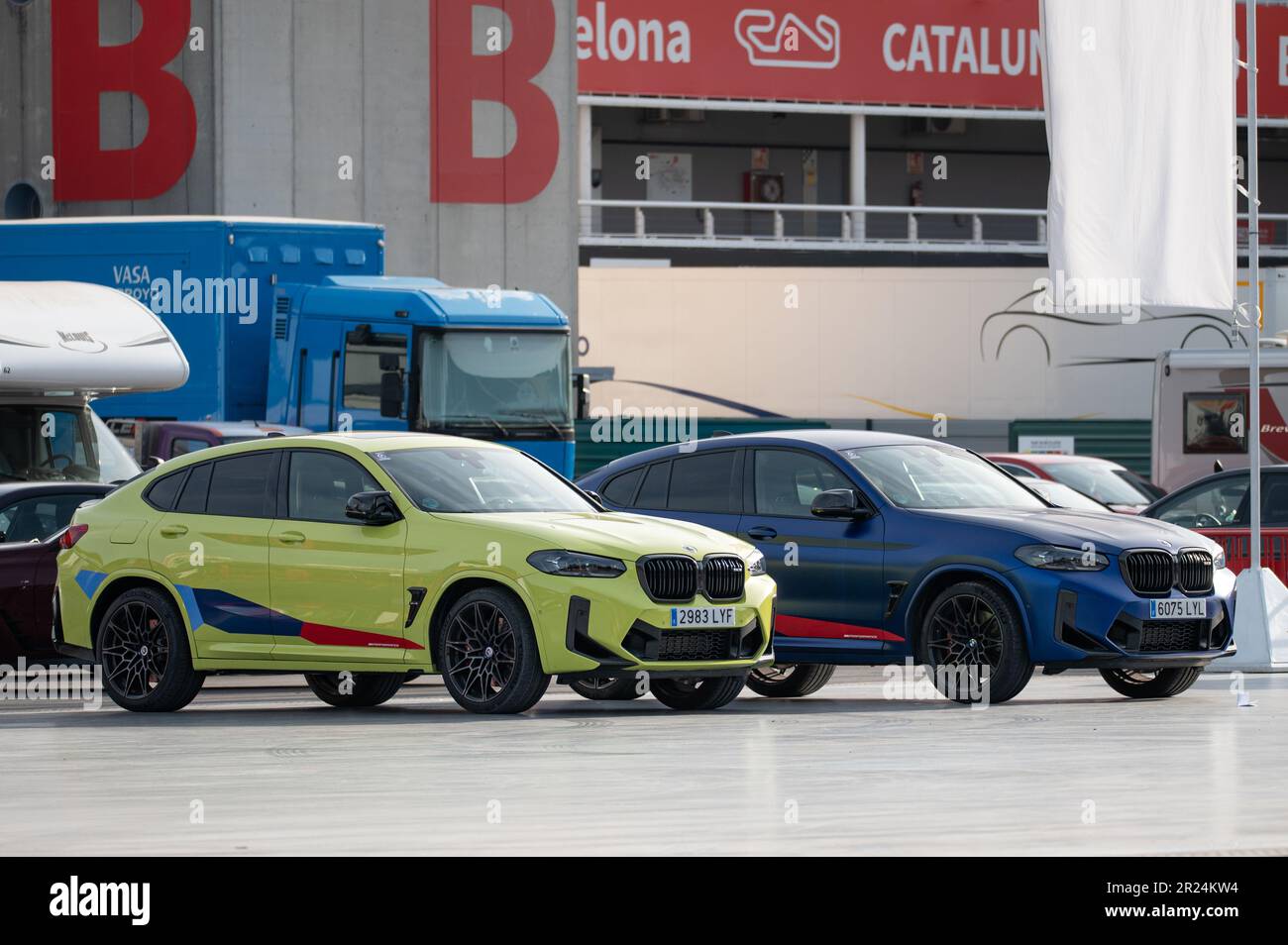 Detail of a pair of BMW X4 sports SUVs, one lime yellow and the other ...