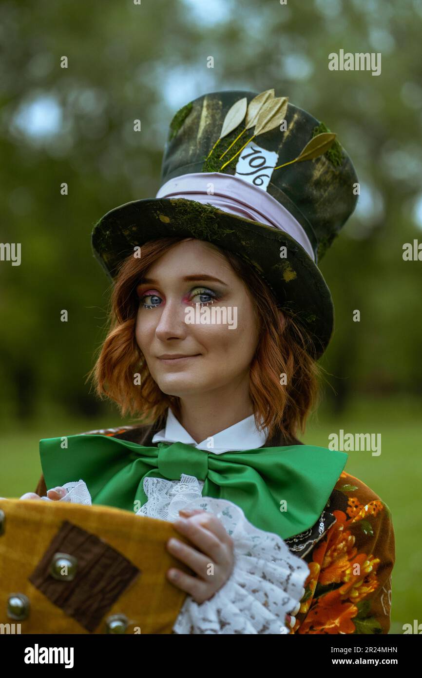 Beautiful woman as mad hatter with hats in nature Stock Photo - Alamy