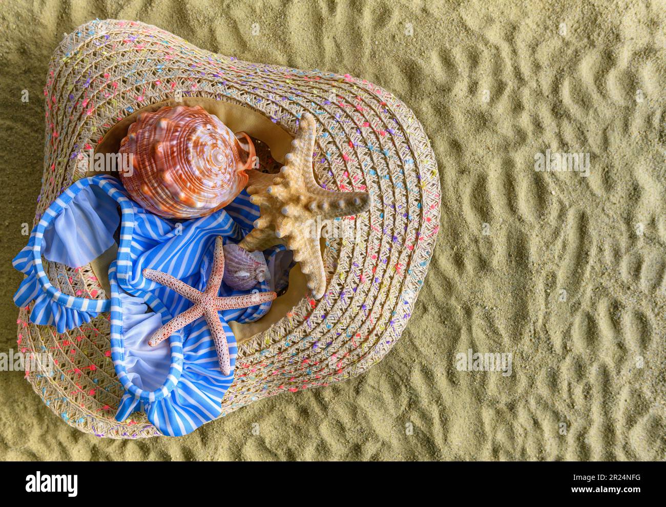 Hat with swimsuit and seashells Stock Photo - Alamy