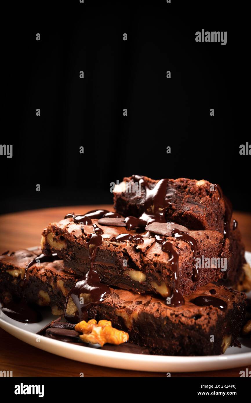 Three freshly-baked square pieces of brownies topped with syrup and ...