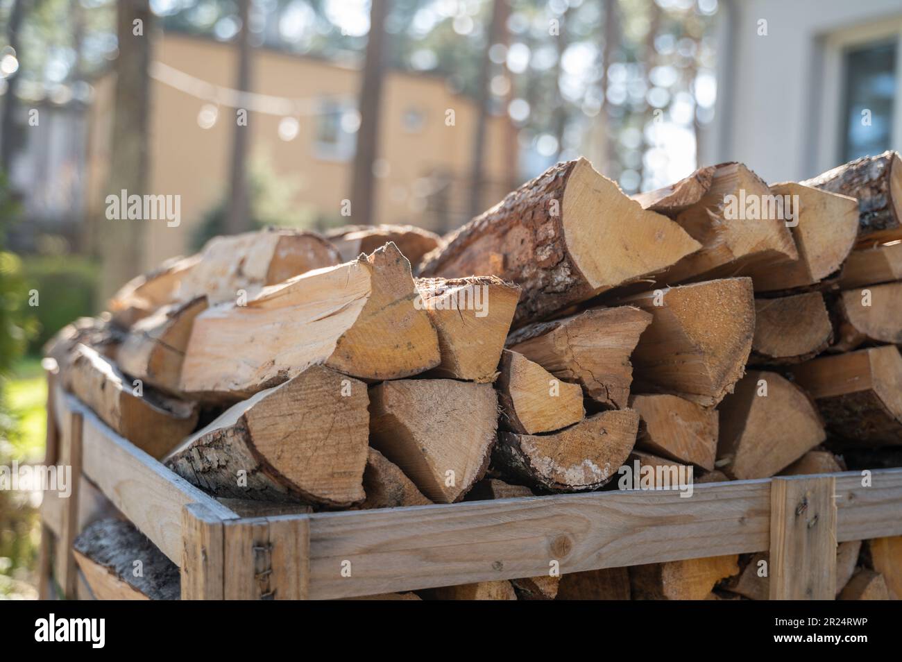 Pallet with firewood on private backyard with courtyard on background ...
