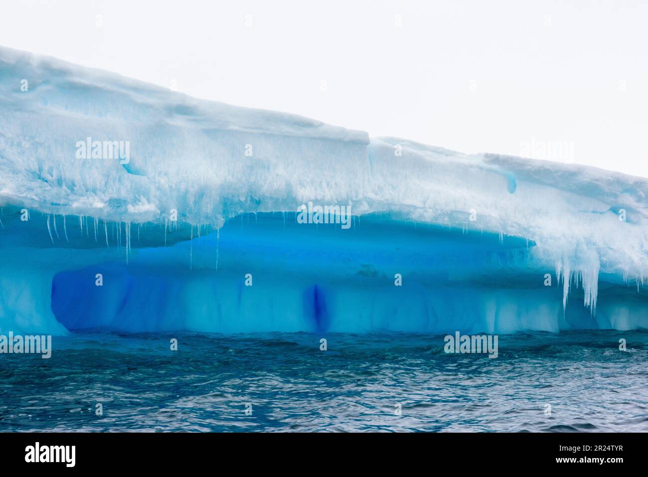 Brown Bluff, Antarctica. Light reflects off the blue hued ice shelf in ...