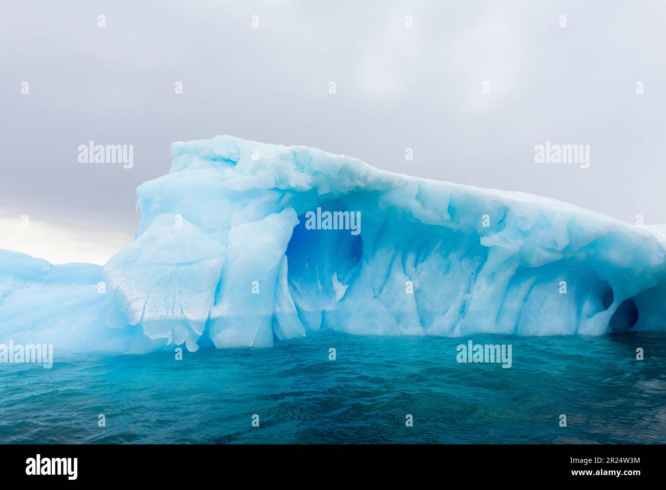 Brown Bluff, Antarctica. An iceberg juts out of the sea in the ...
