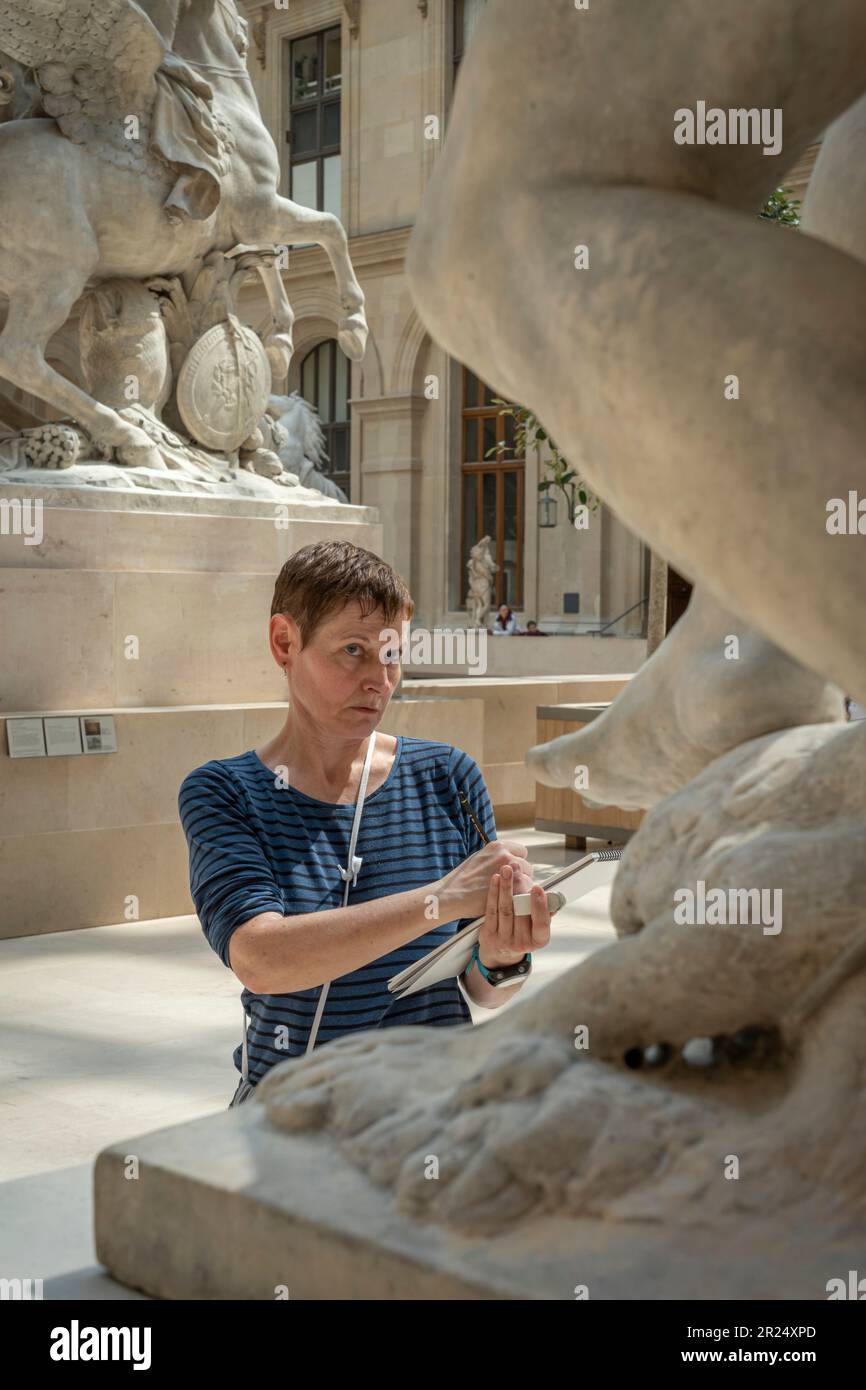 Paris, France - 05 13 2023: Louvre Museum. A woman draws the Sculpture ...