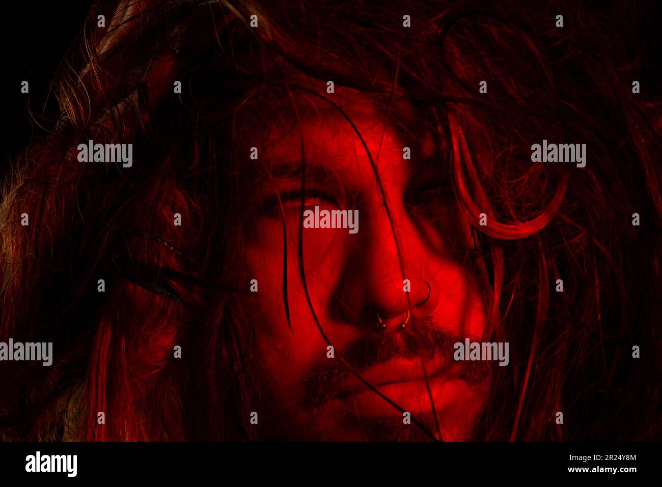 Close-up portrait of handsome young man with hair all over his face ...