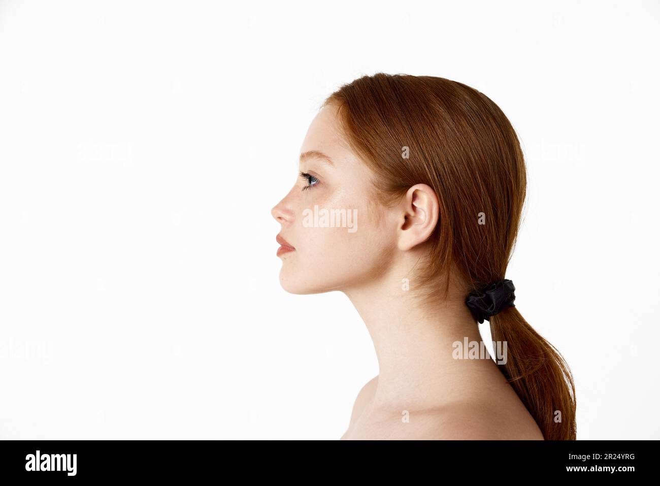 Side view portrait of beautiful, young, redhead girl with ponytail ...