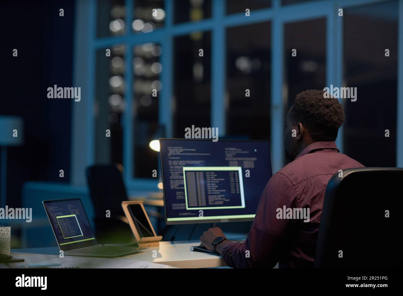 Rear view of African American programmer working with computer codes on ...