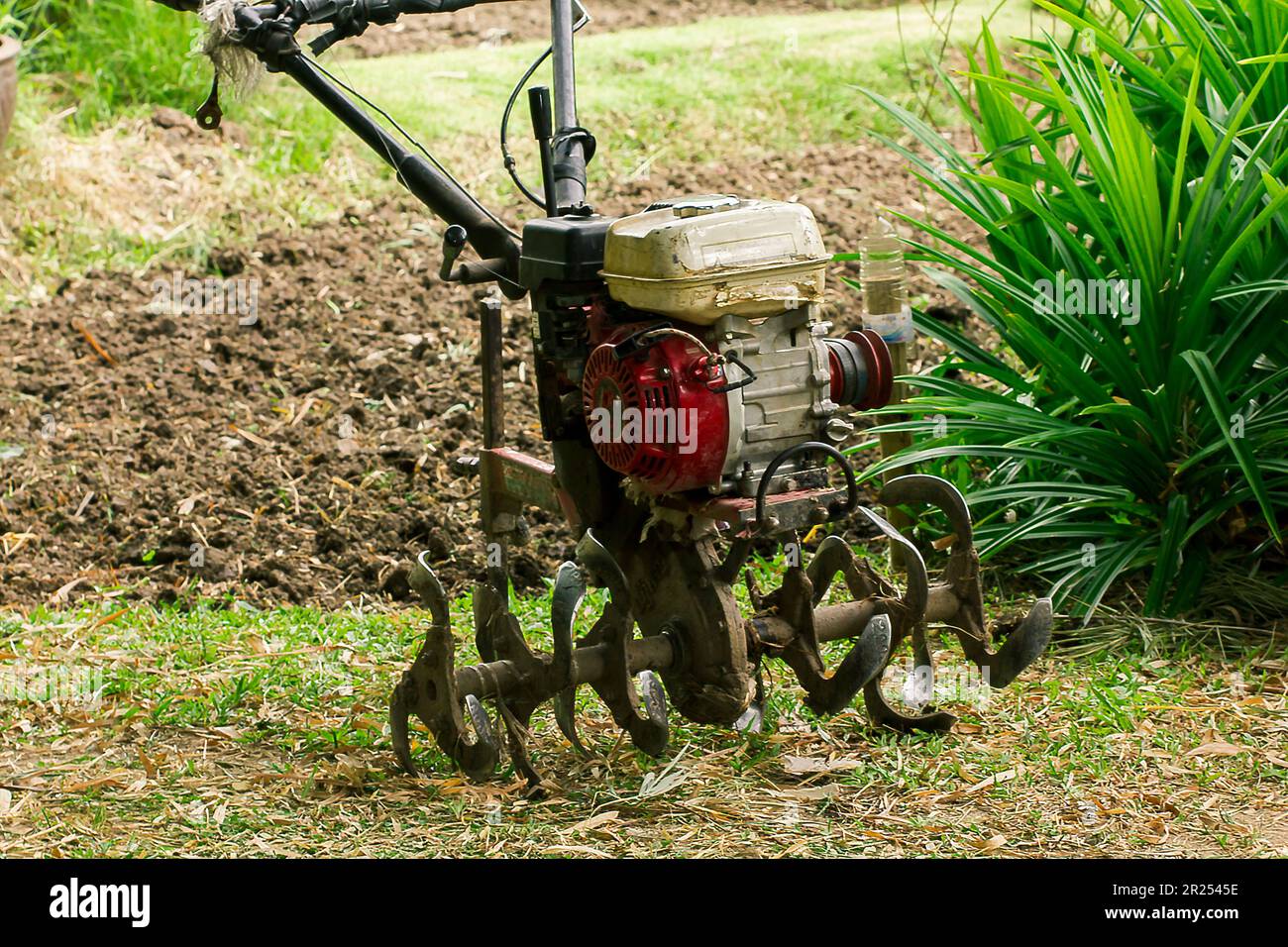 Rotary tiller helps to prepare the soil for modern farmers Stock Photo ...