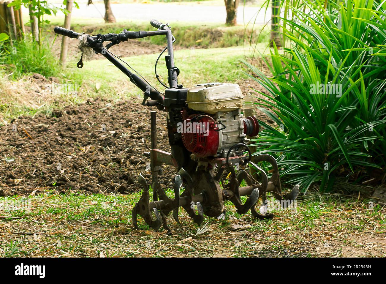 Rotary tiller helps to prepare the soil for modern farmers Stock Photo ...