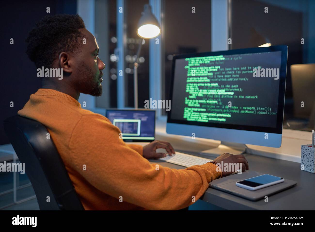 African American developer sitting at his workplace and concentrating ...