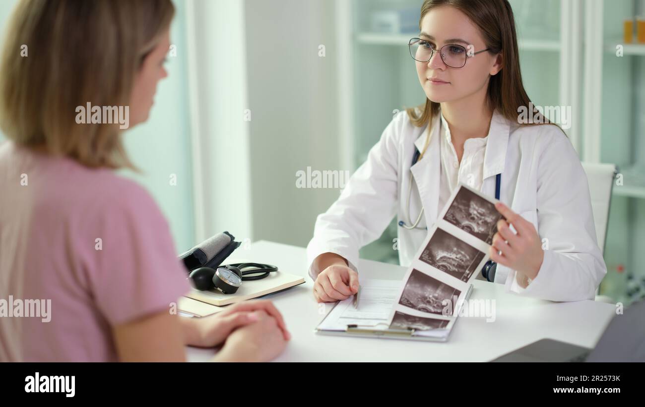 Doctor communicating with patient and examining results of ultrasound ...