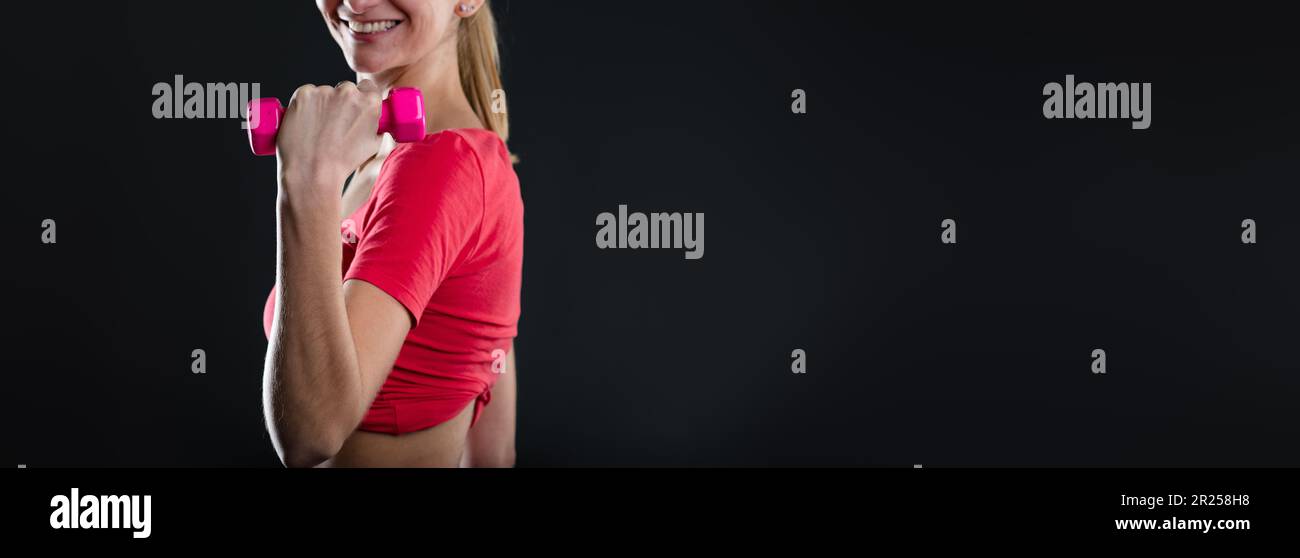 Fitness woman lifting pink weight, blurry in background. Proud blonde ...