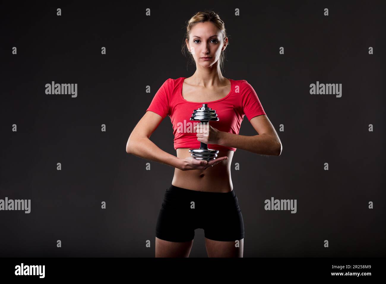 Gym concepts - fitness, stretching, weight lifting. Woman proudly holds ...