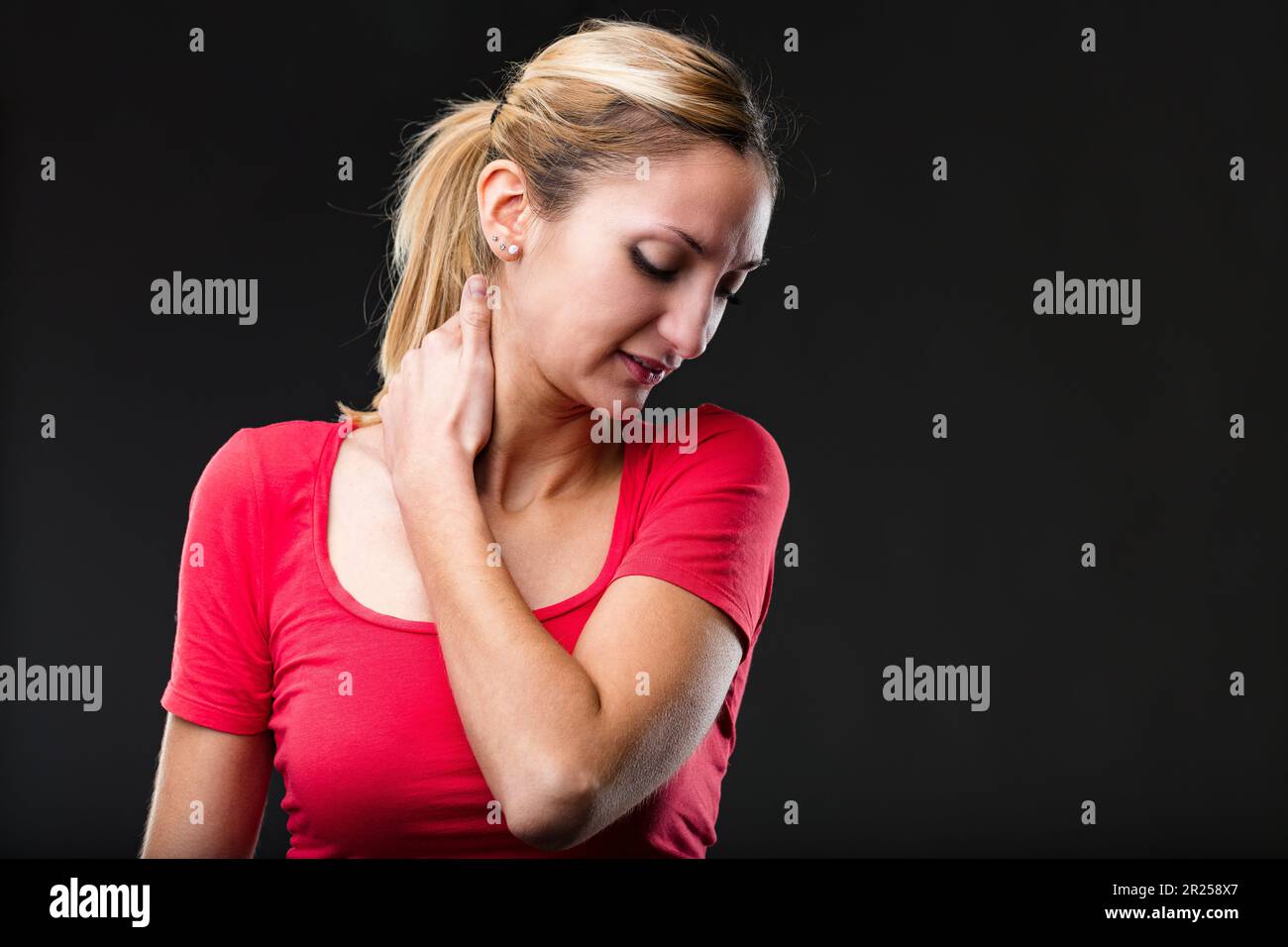Neck pain: woman in red shirt shows discomfort, facial grimaces. Tired ...