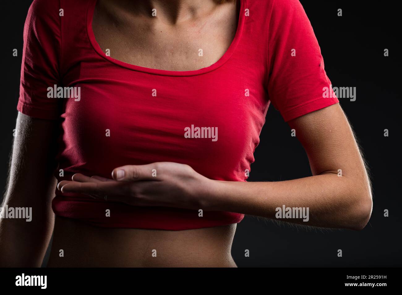 Woman's chest highlighted by her hand underneath, emphasizing care ...