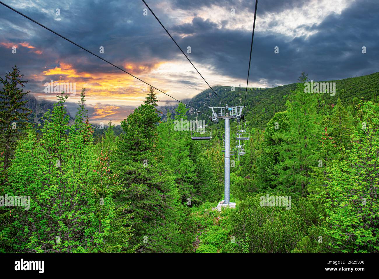 Tourist double lift above the forest on the mountain slope Stock Photo ...