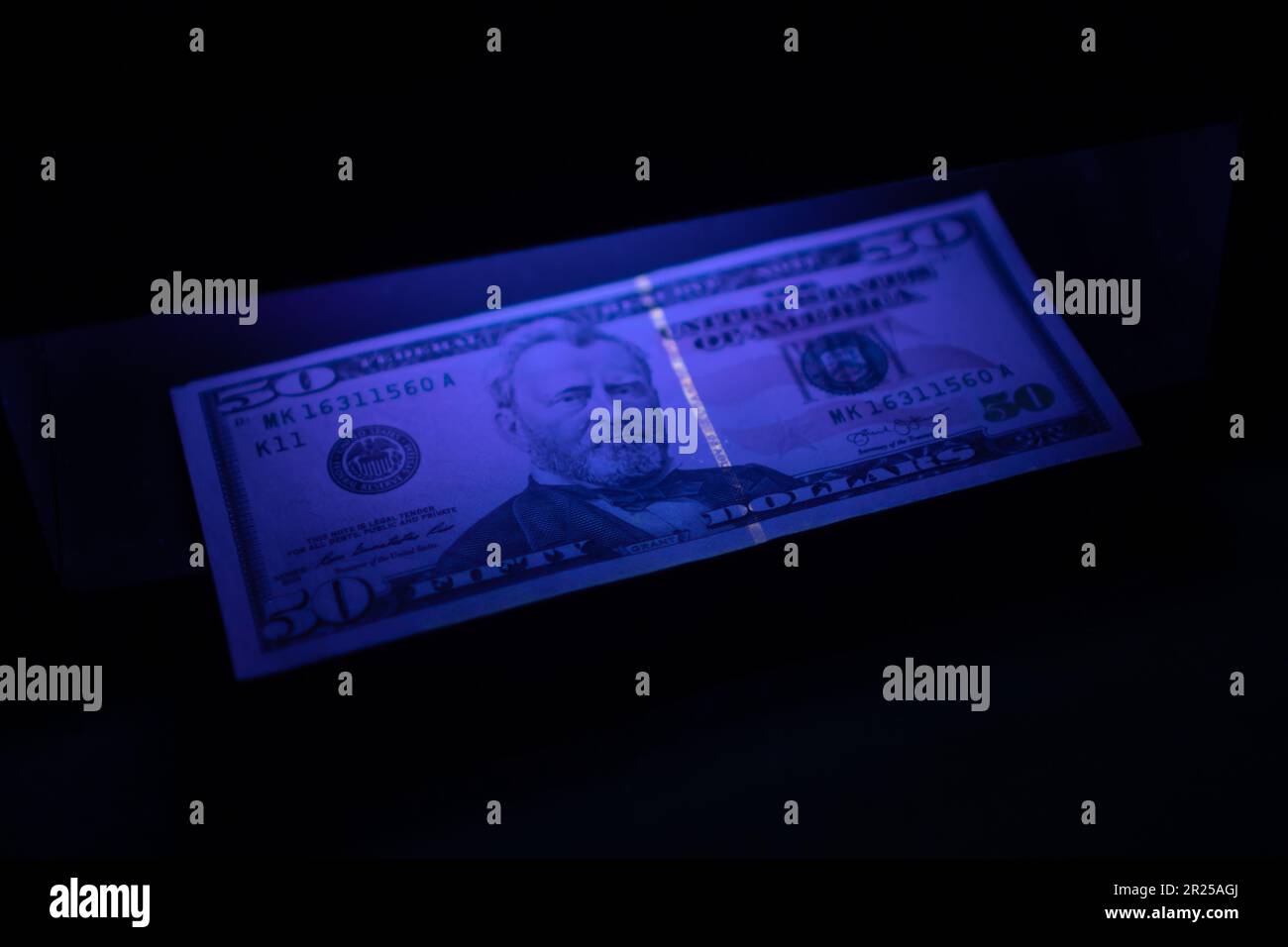 Close-up of dollars under an ultraviolet lamp. Inspection of a dollar ...