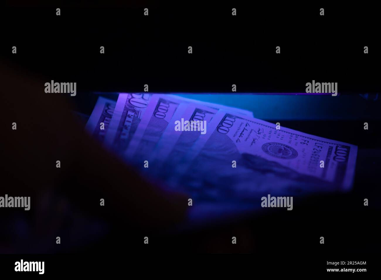Close-up of dollars under an ultraviolet lamp. Inspection of a dollar ...