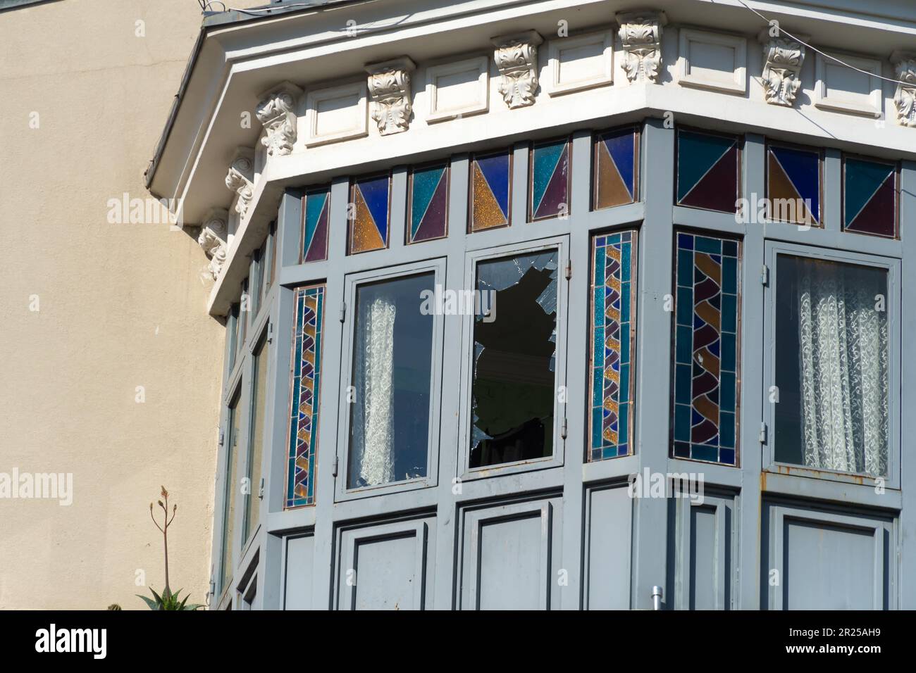 Close-up of a broken window on the beautiful facade of a balcony with ...