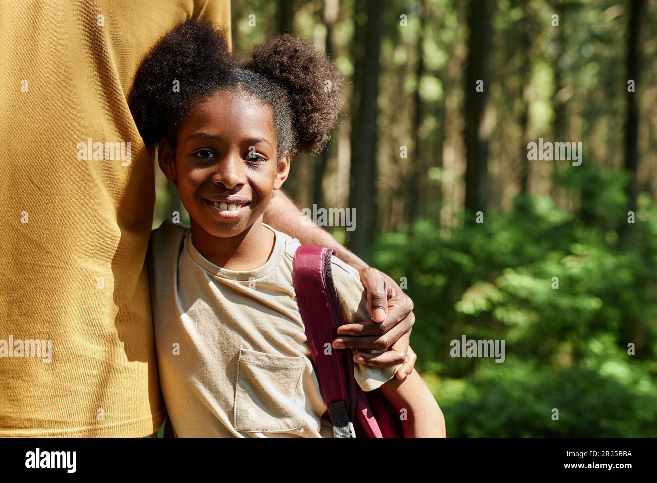 Portrait of happy little girl smiling at camera while going camping ...