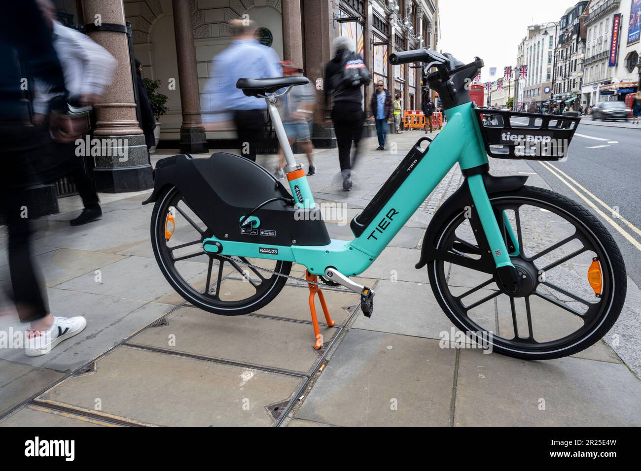 London, UK. 17 May 2023. The public passes an electric hire cycle on a ...