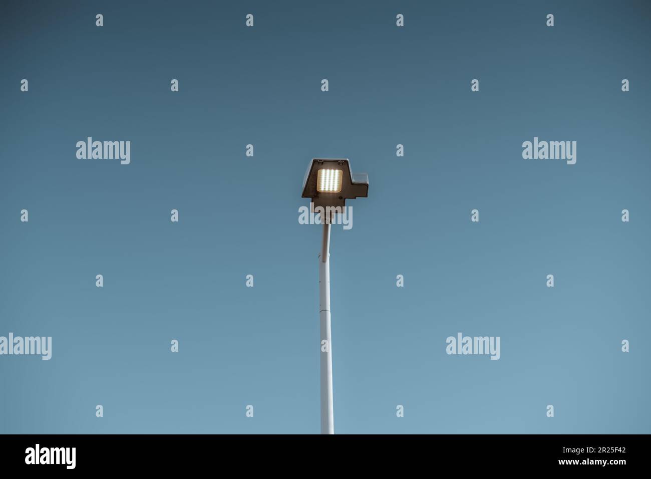 A Pole Mounted LED Flood Light in Lisbon emits light during plain ...